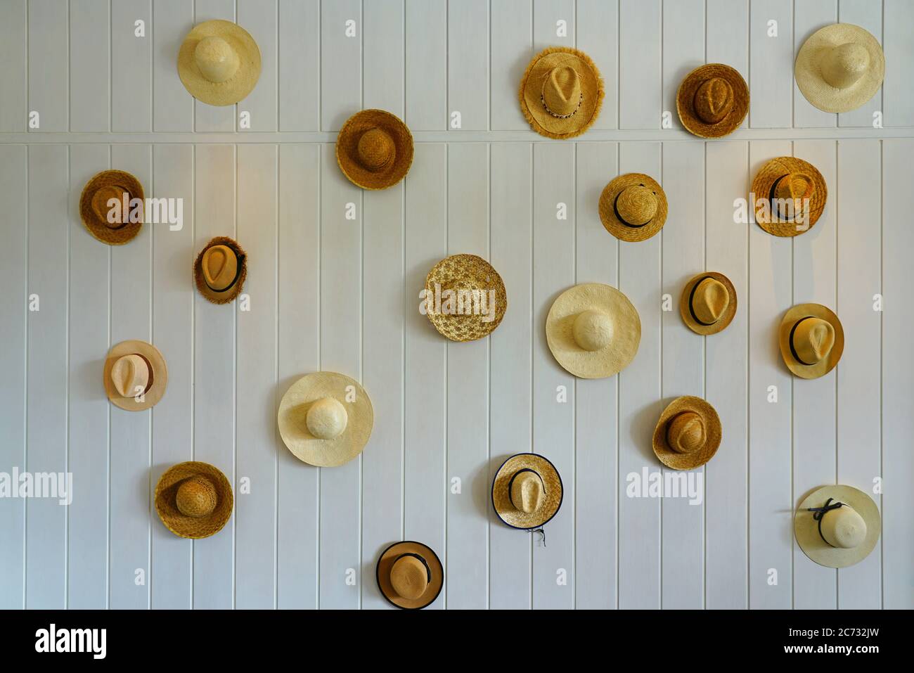 Display of summer straw hats on a white wall Stock Photo - Alamy