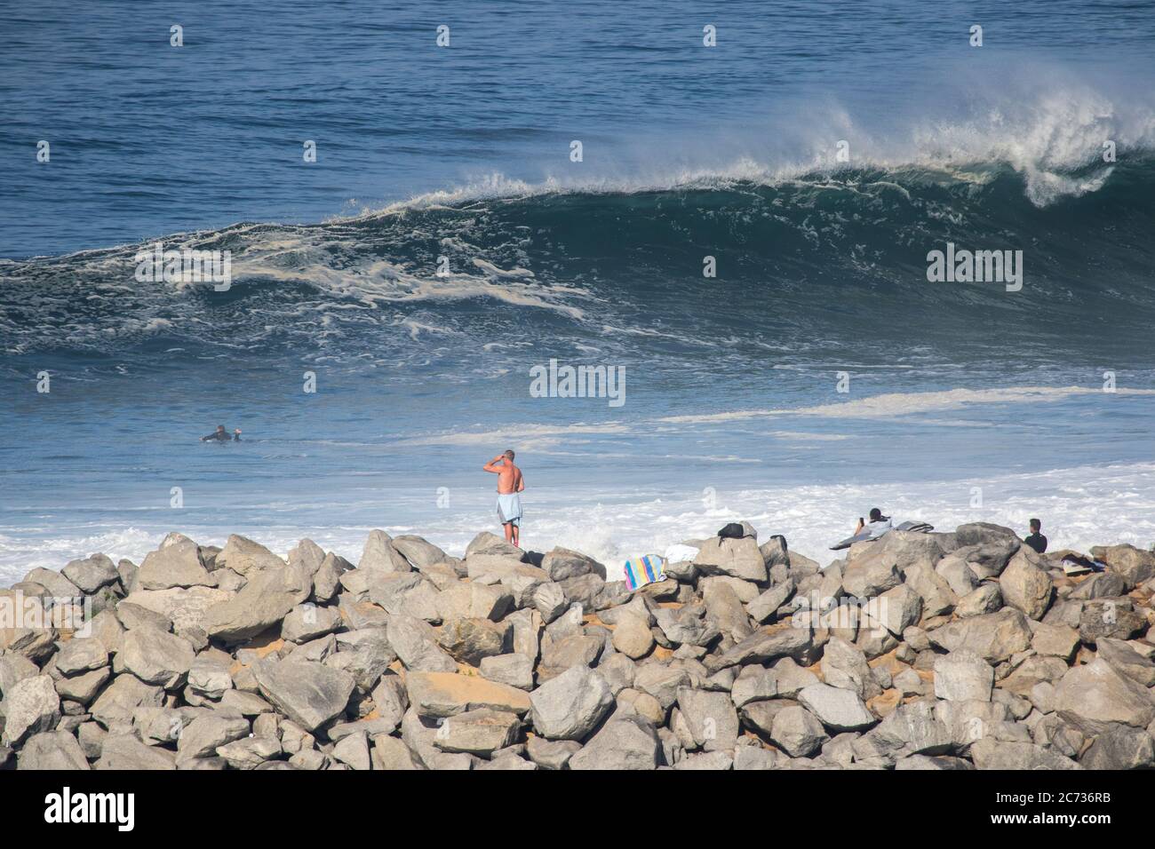 Man watching big crashing waves from the jetty at the Wedge Newport ...