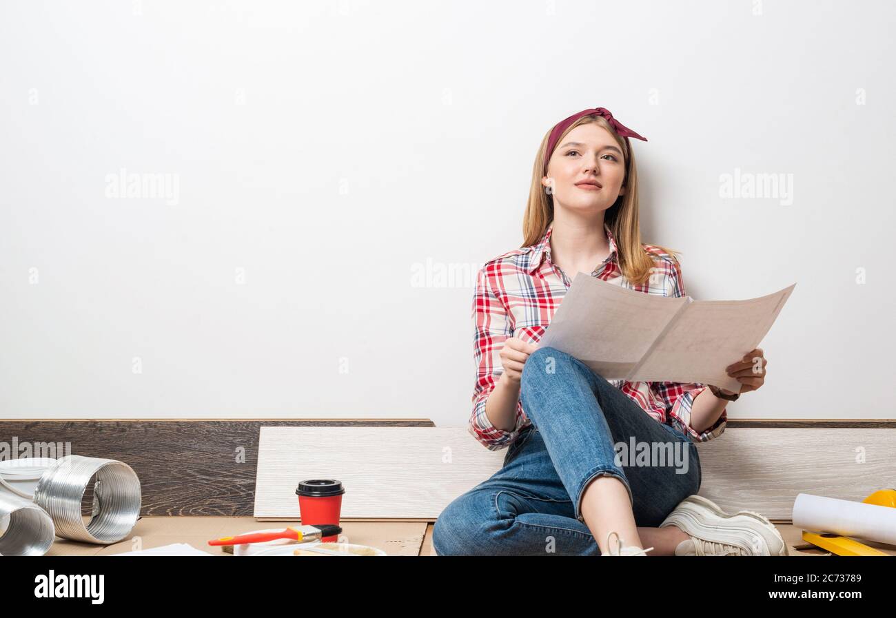 Beautiful girl sitting with paper blueprint Stock Photo - Alamy