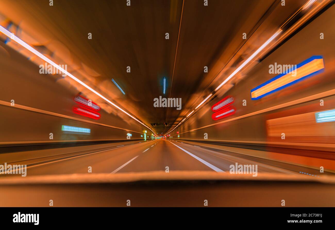 Red light tunnel drive through a subway by a car with the view through ...