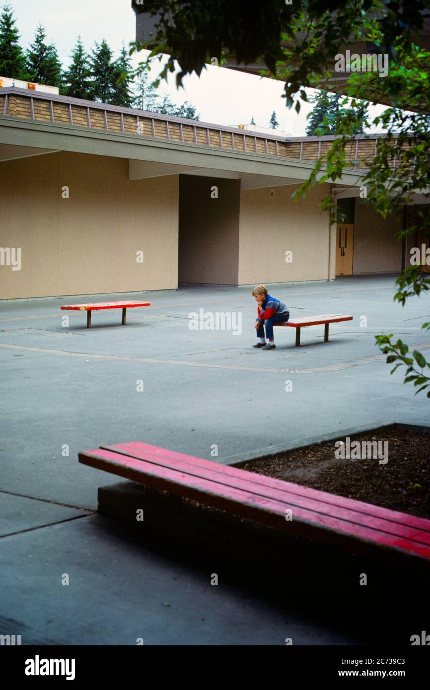 1970s SOLITARY DOWNCAST YOUNG BOY SITTING ALONE IN EMPTY SCHOOL YARD ...