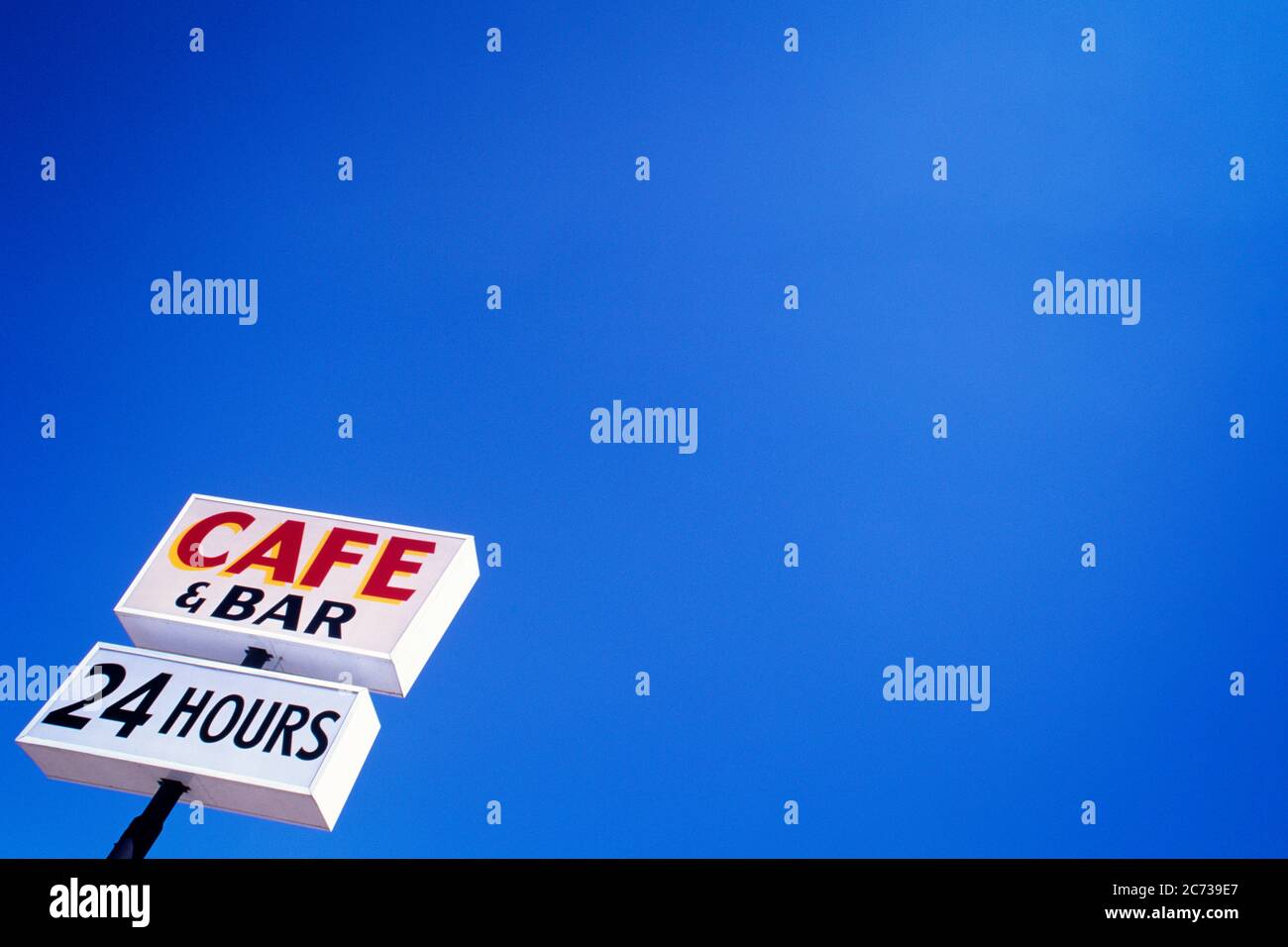 24 HOURS CAFE AND BAR SIGN LOW ANGLE LOOKING UP IN TO BLUE CLOUDLESS ...