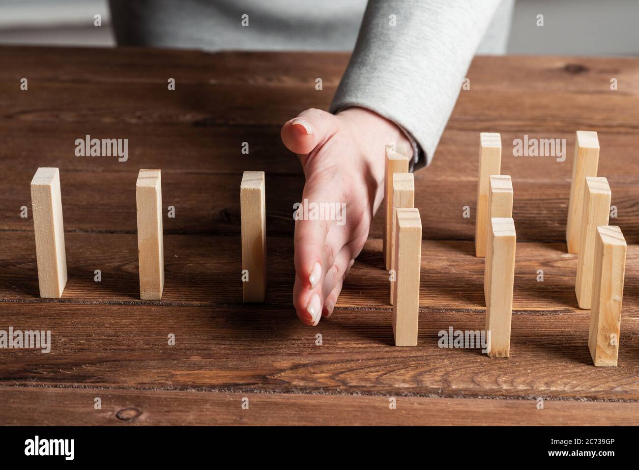 Business woman hand stop domino effect Stock Photo - Alamy