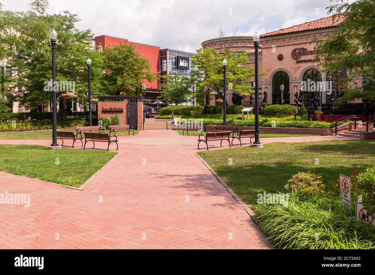 A walkway into a park with benches in the South Side Works complex ...