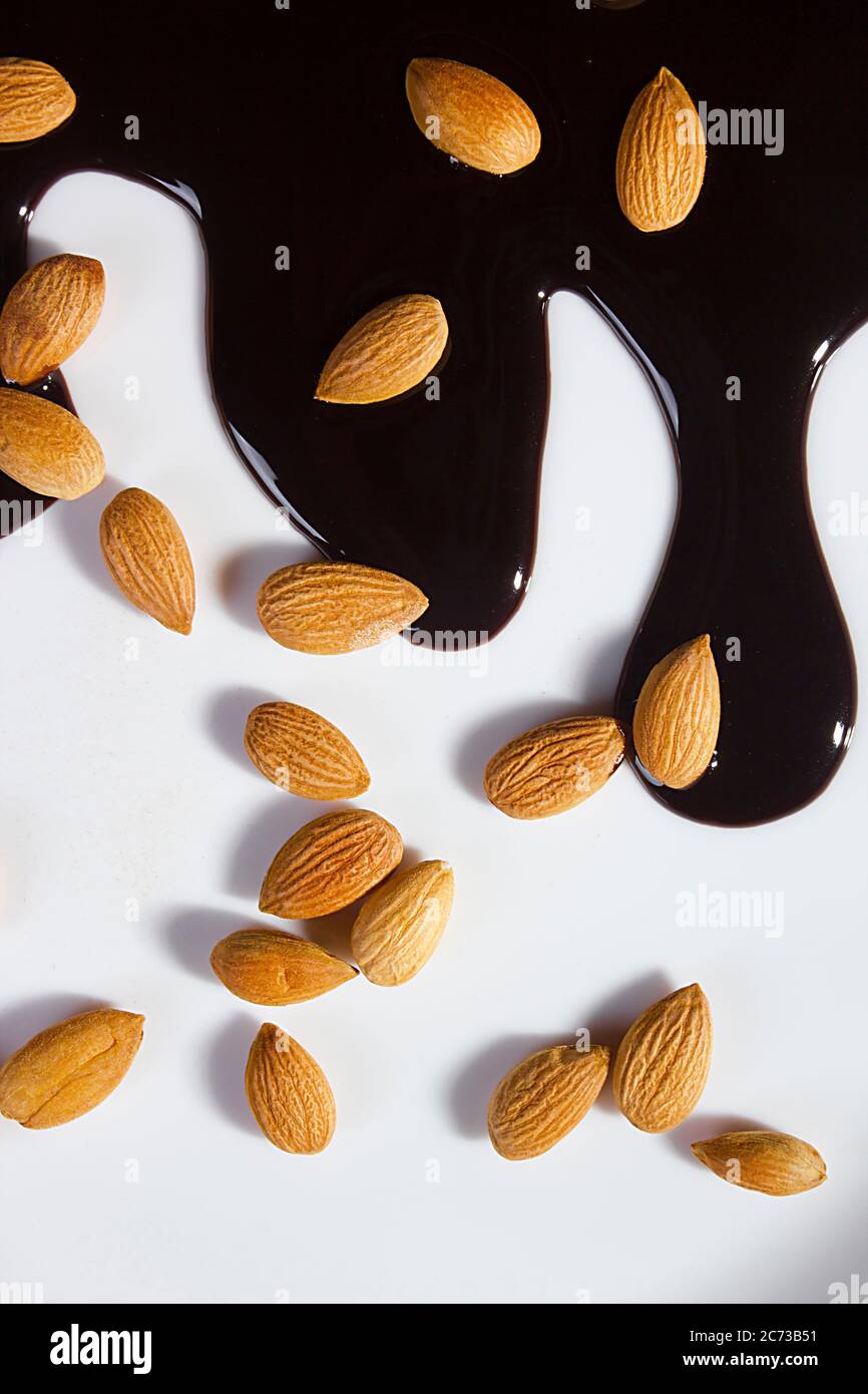 Almonds and melted chocolate on a white background Stock Photo - Alamy