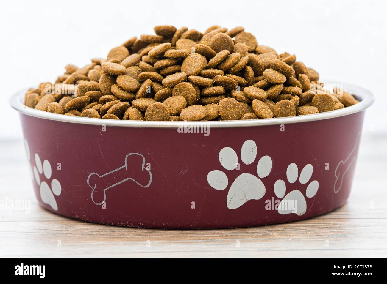 Dry dog and cat food in scratched red bowl. Pile of kibblses Stock ...