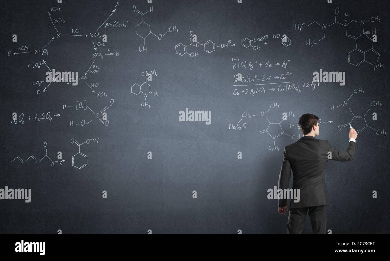 Scientist writing formulas on chalkboard Stock Photo - Alamy