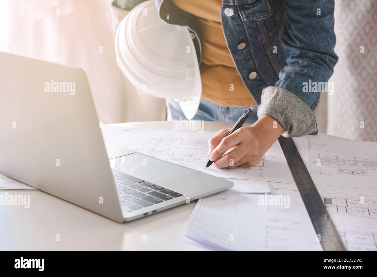 Engineer or architect holding pen with drawings in construction on ...