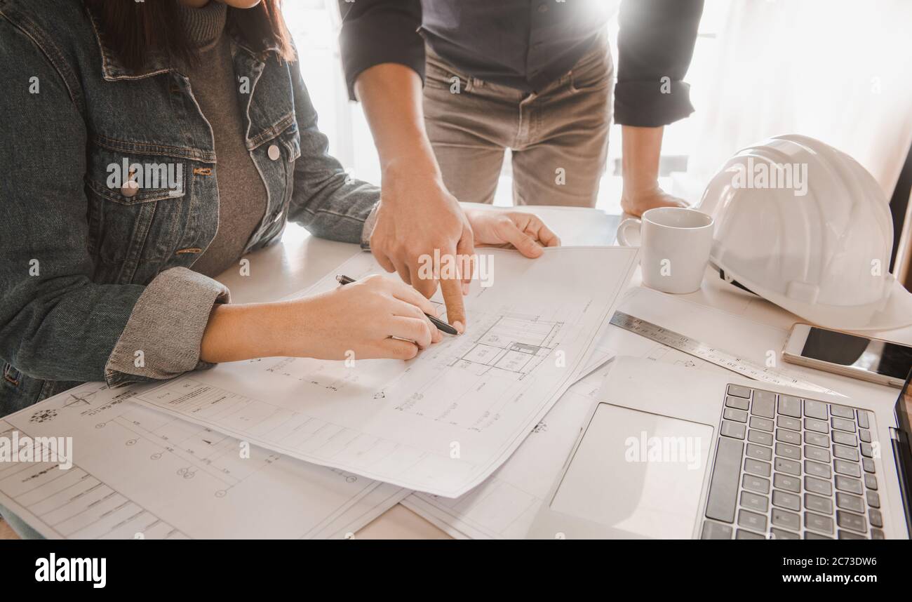 Architects are discussing and planning together at the desk with ...