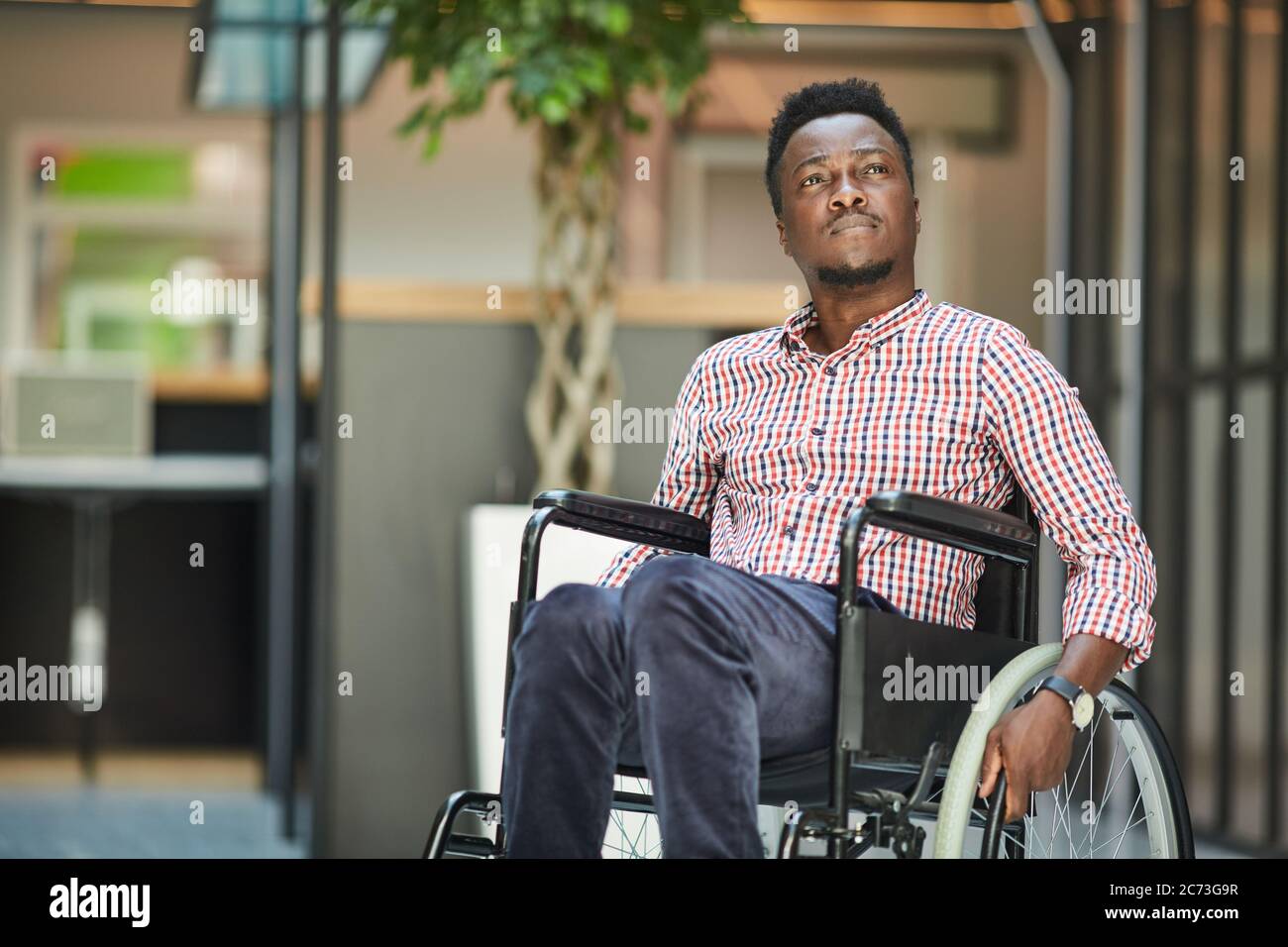 African disabled office worker sitting in wheelchair he is at office ...