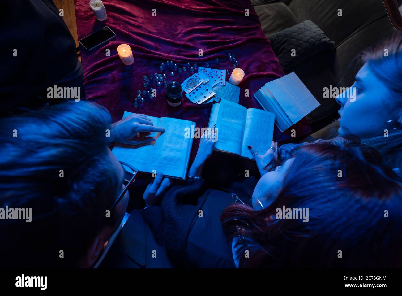 Two women and a guy are reading a mysterious books, close view Stock ...