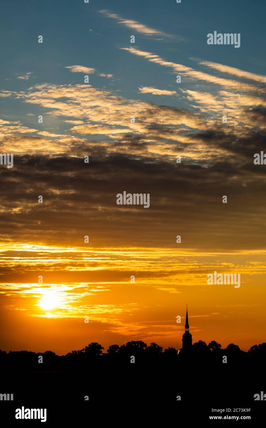Schellerten, Germany. 14th July, 2020. The sun rises behind the tower ...
