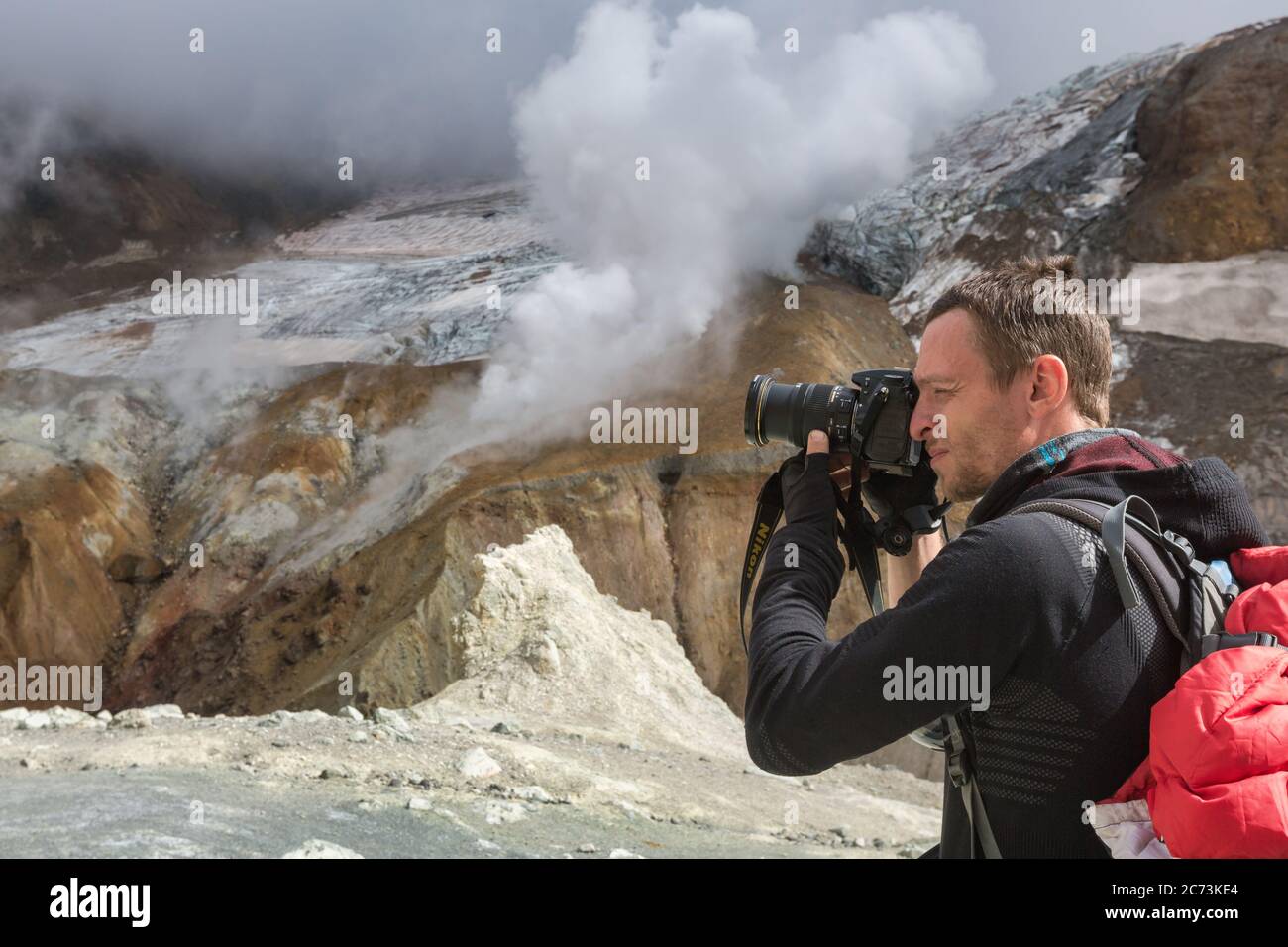 Male photographer takes pictures of dramatic volcanic landscape ...