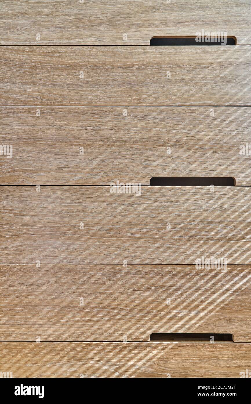 Wooden cupboard with drawers in daylight. Modern wooden furniture ...