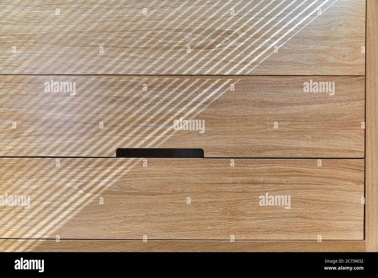 Wooden cupboard with drawers in daylight. Modern wooden furniture ...
