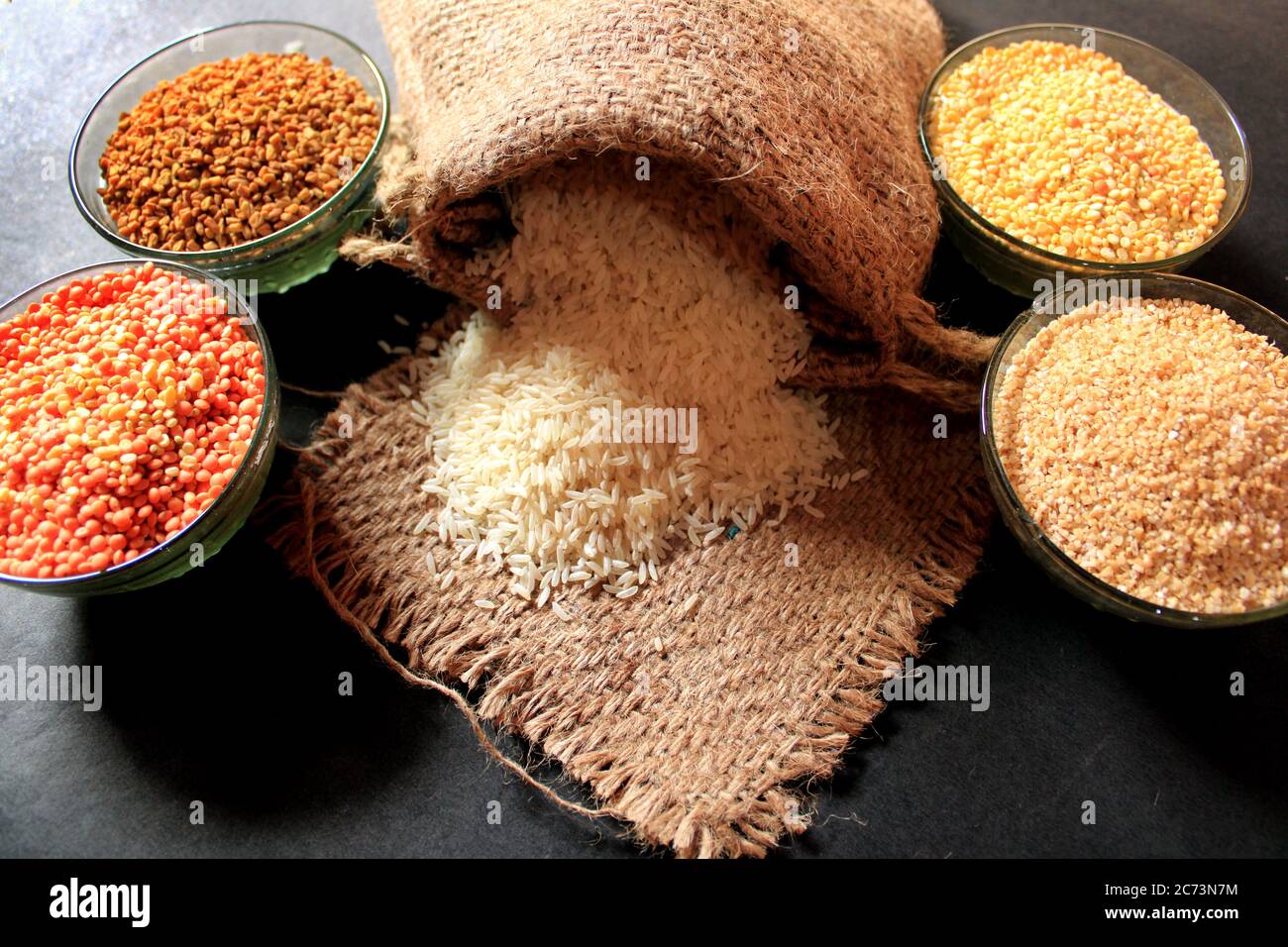 Rice out from small sack isolated on black background. Different ...