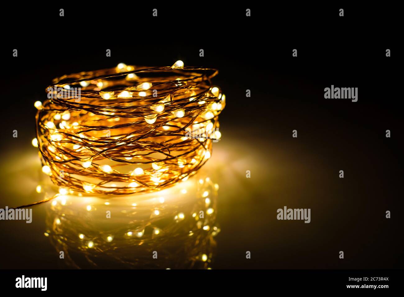 Yellow colored light chain for decoration placed on a reflective ...