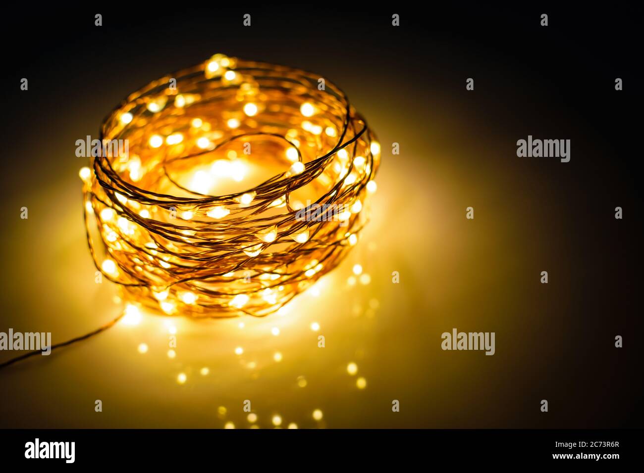Yellow colored light chain for decoration placed on a reflective ...