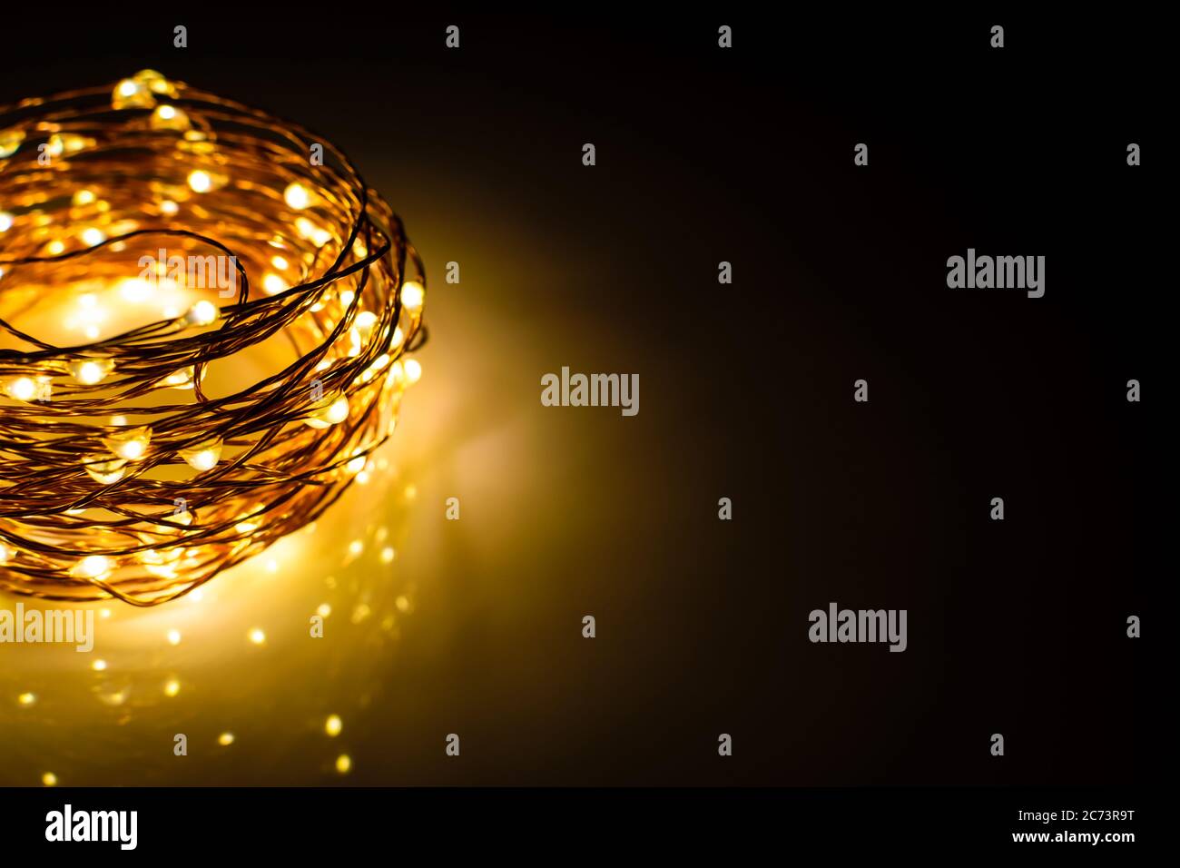Yellow colored light chain for decoration placed on a reflective ...