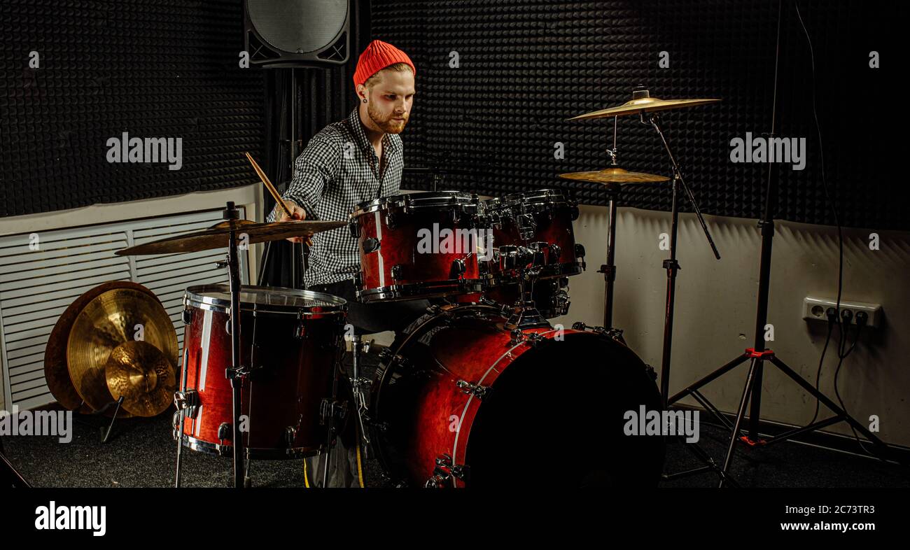 young caucasian drummer rehearsing on drums before rock concert ...