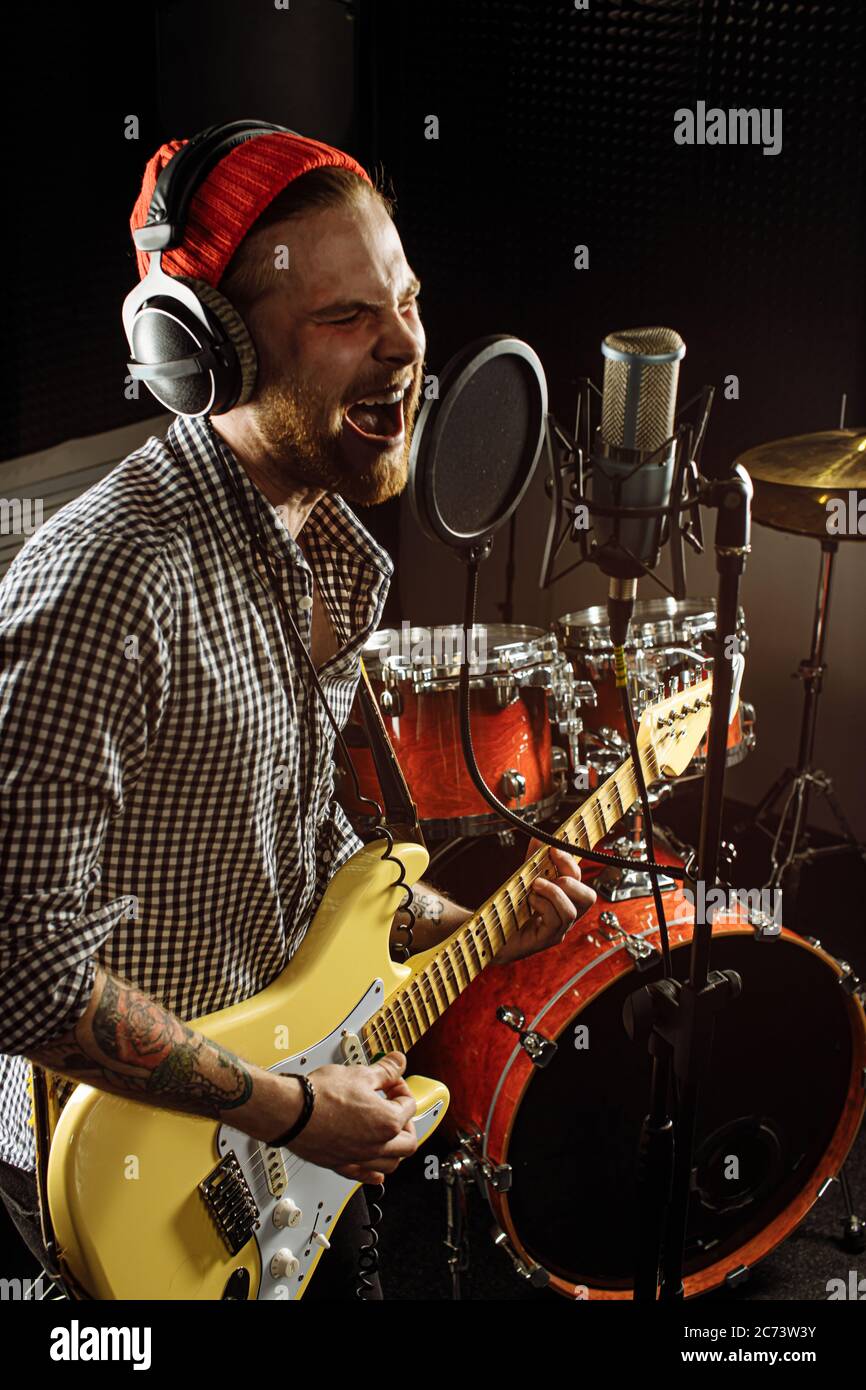 young caucasian gorgeous musician play electric guitar and sing on ...