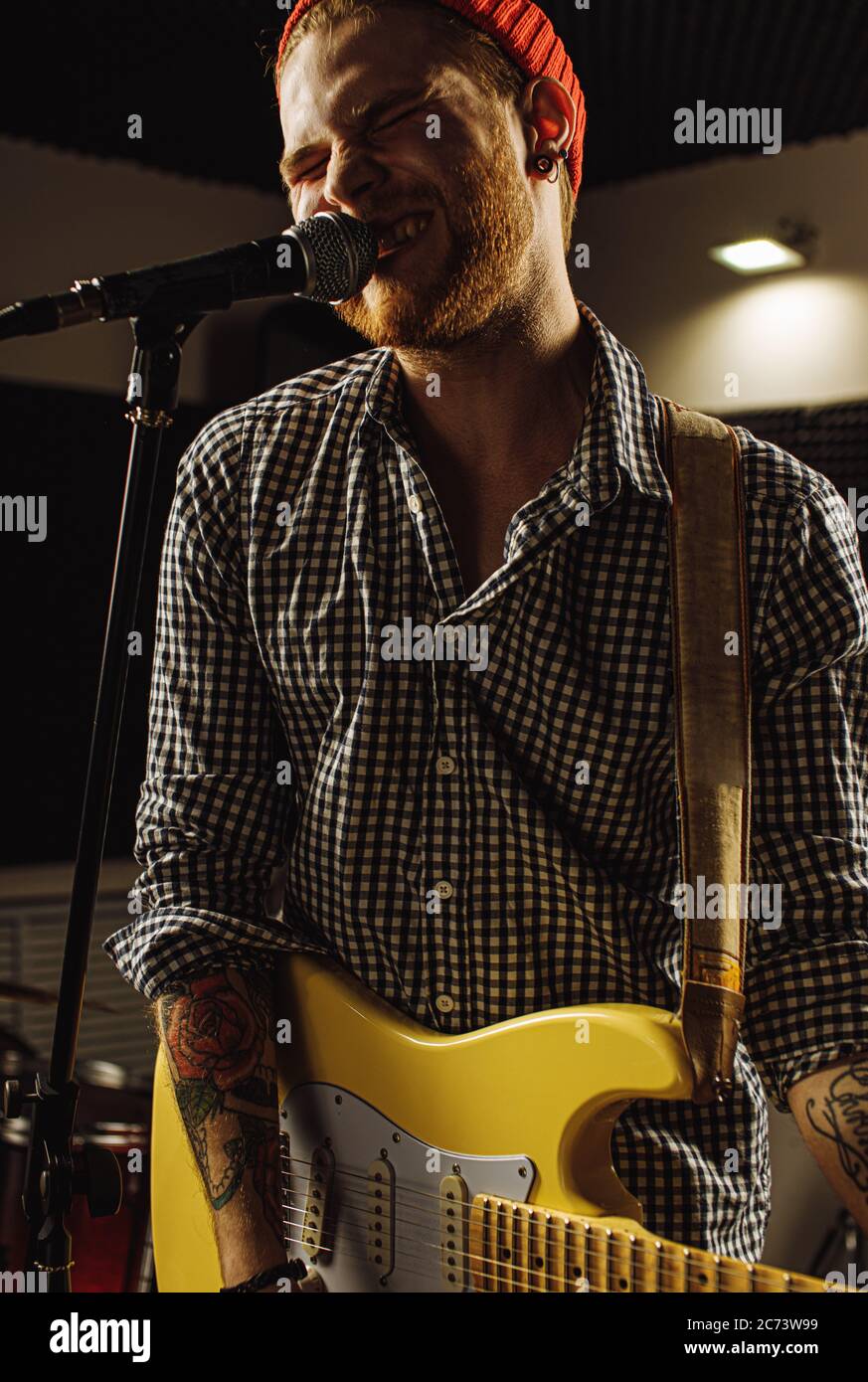 emotional caucasian singer play electric guitar and sing on microphone ...