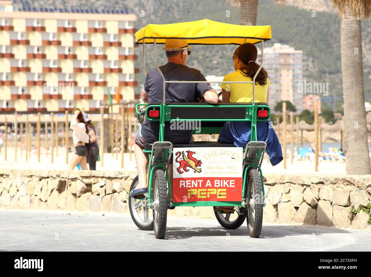 Four wheel bicycle ride on the promenade of Magaluf, Majorca, Balearic ...