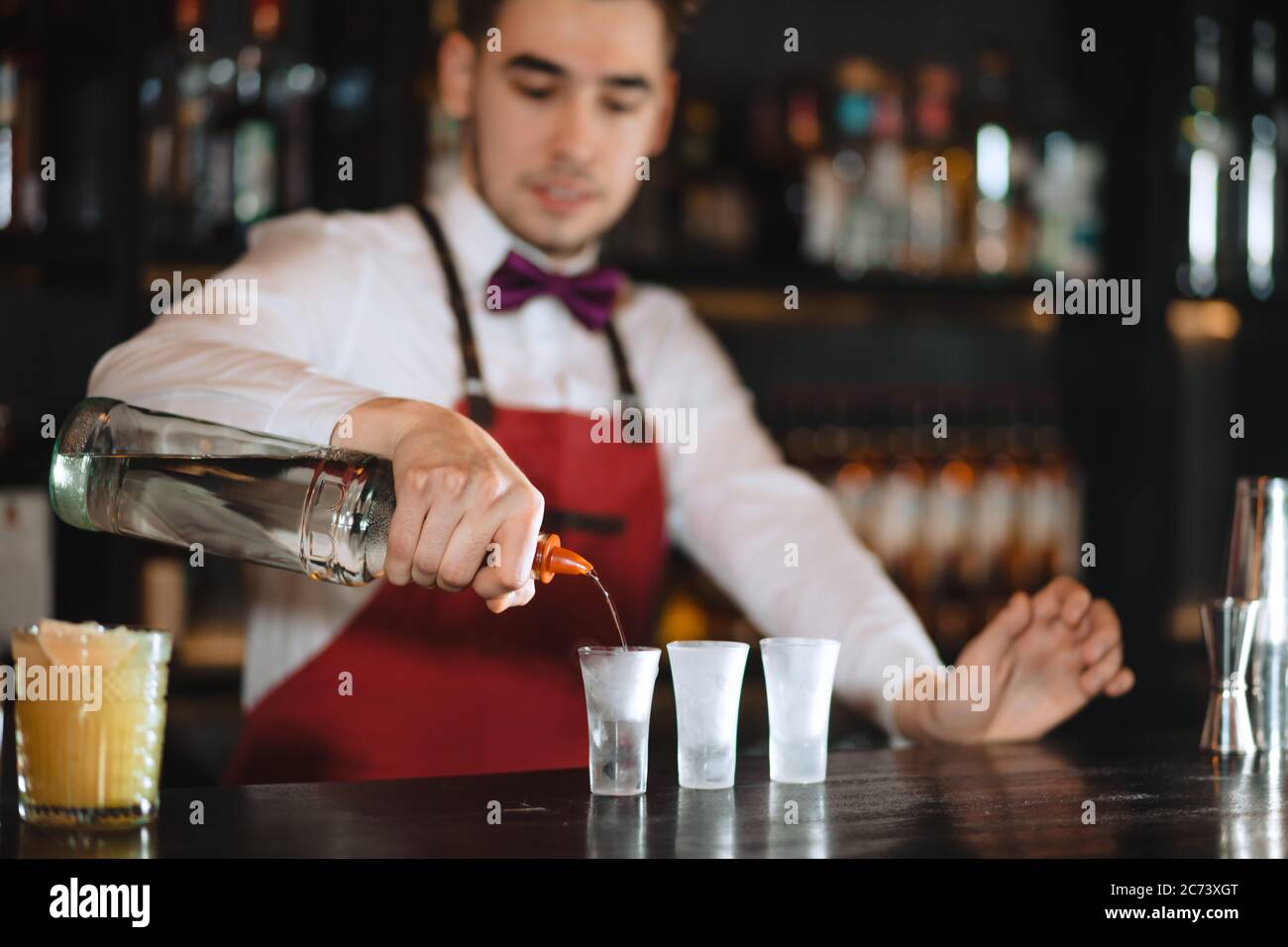Expert barman in elegant uniform working at night party at popular ...