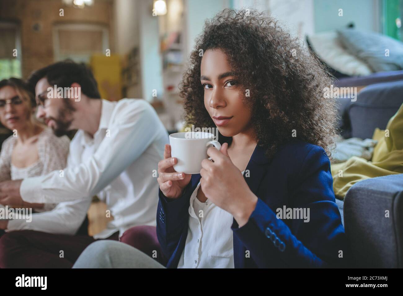 Girl with coffee, girlfriend and boyfriend at distance with papers ...
