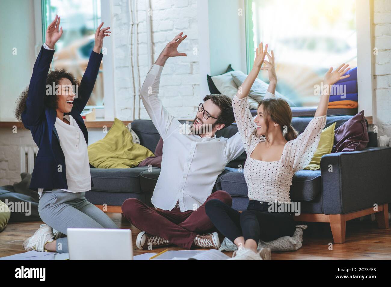 Three young students rejoicing in overall success Stock Photo - Alamy