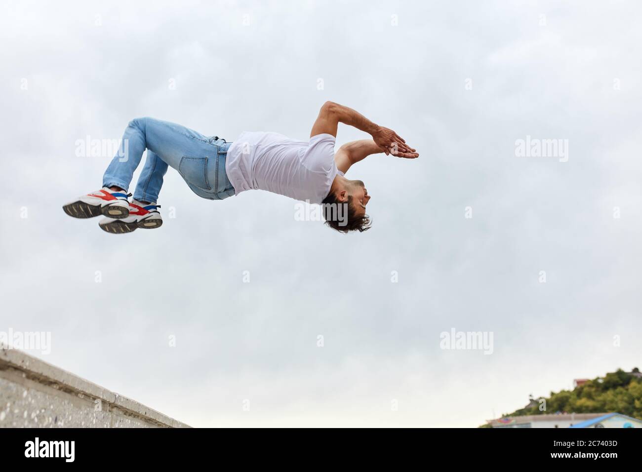 fearless guy jumping from the wall, sportsman flying in the air, risk ...