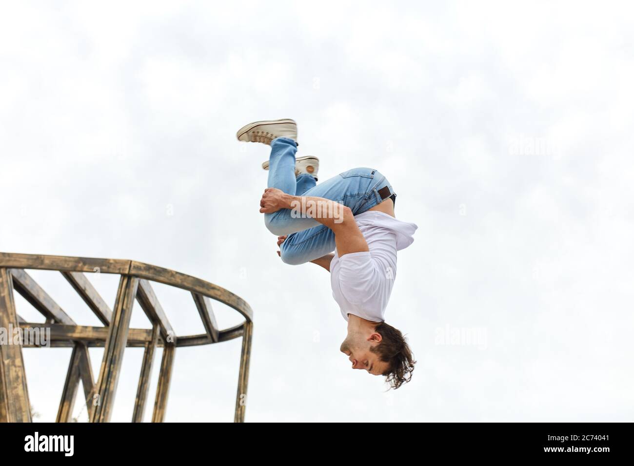 man holding legs performing a stunt upside down. full length side view ...
