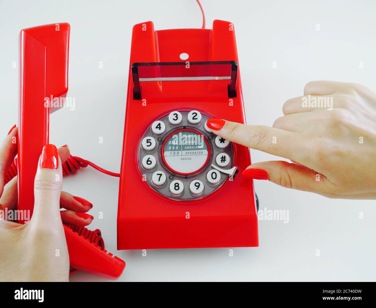 Female hands with red manicured nails make a telephone call, dialling ...