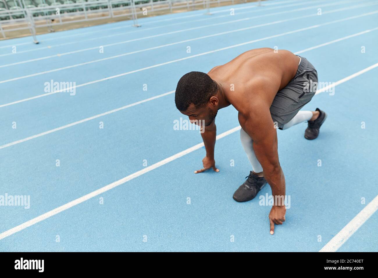 sporty ambitious guy doing exercises for legs st the stadium. full ...