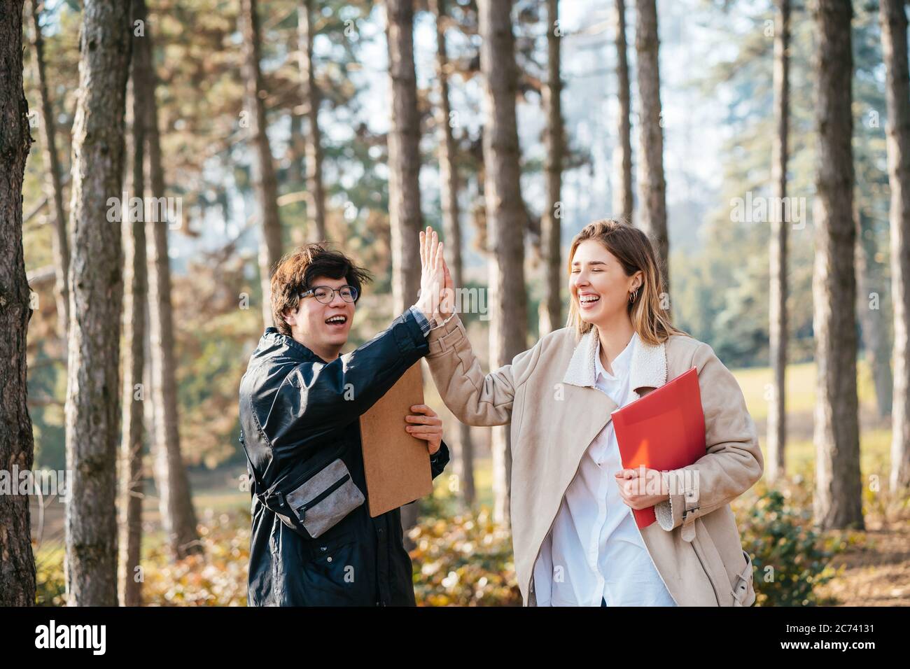 Man give high five woman in the forest Stock Photo - Alamy