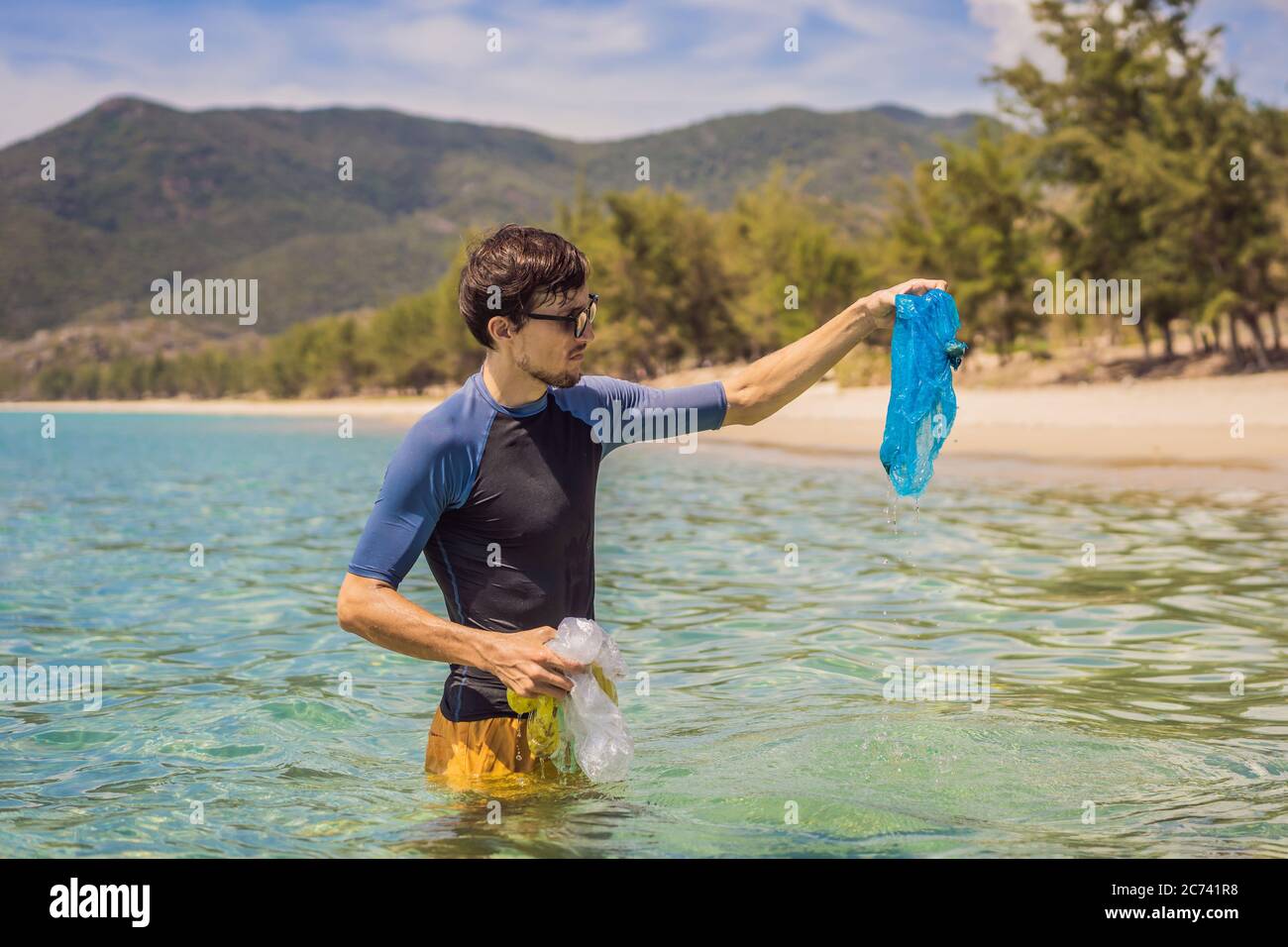 Man collects packages from the beautiful turquoise sea. Paradise beach ...