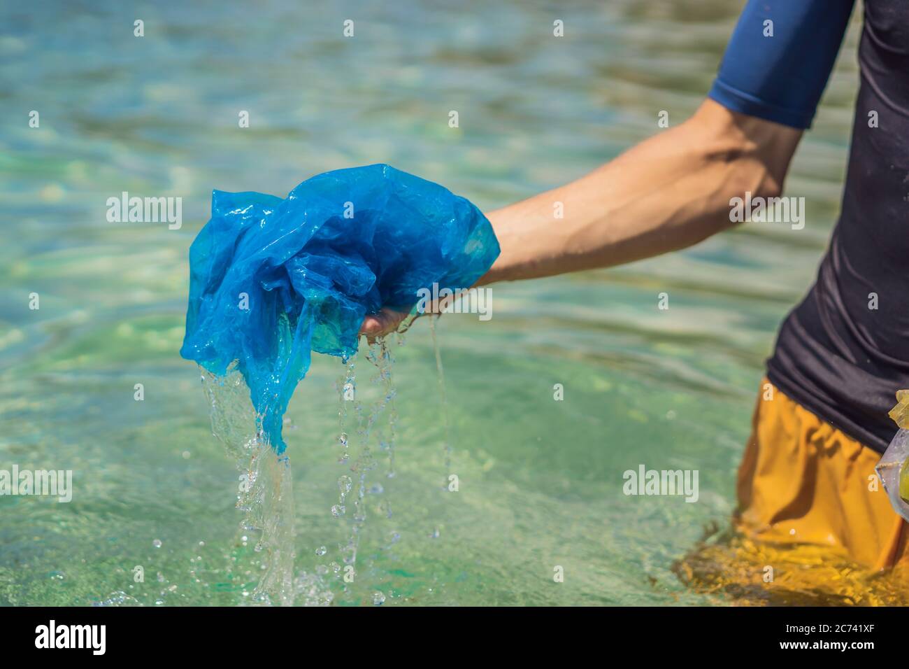 Man collects packages from the beautiful turquoise sea. Paradise beach ...