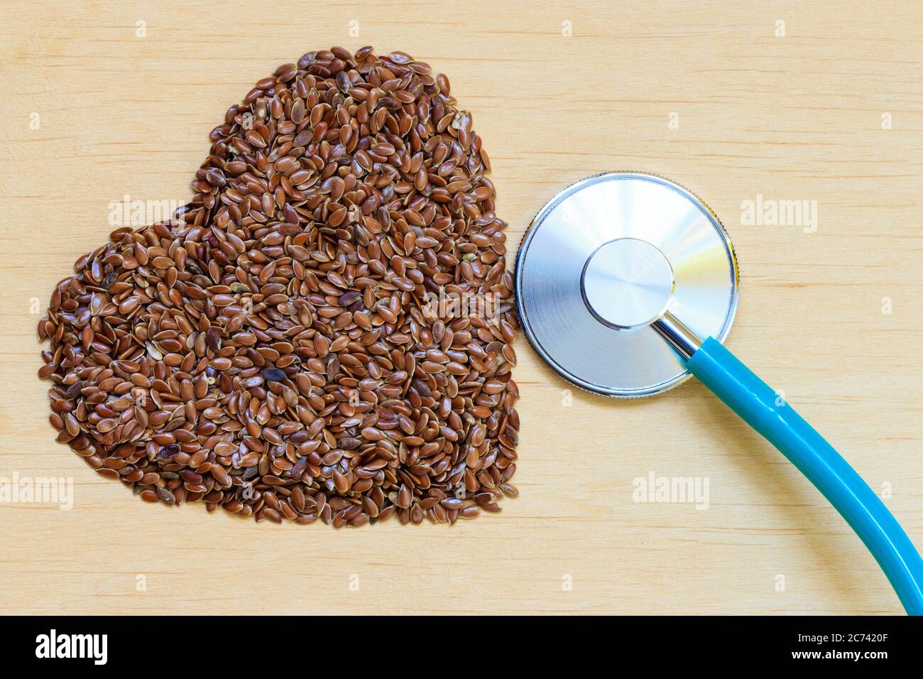 Diet healthcare and checkup concept. Raw flax seeds linseed heart shaped and stethoscope ...