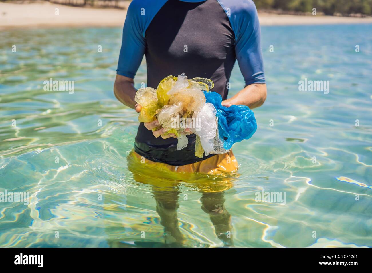 Man collects packages from the beautiful turquoise sea. Paradise beach ...