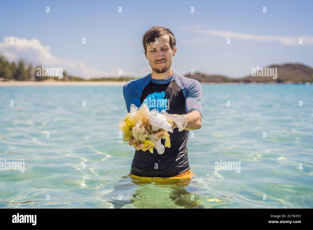 Man collects packages from the beautiful turquoise sea. Paradise beach ...