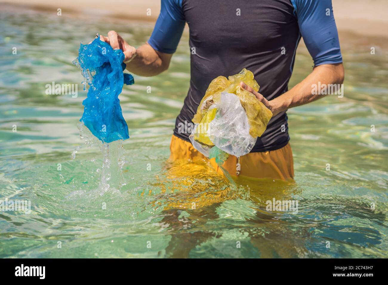 Man collects packages from the beautiful turquoise sea. Paradise beach ...