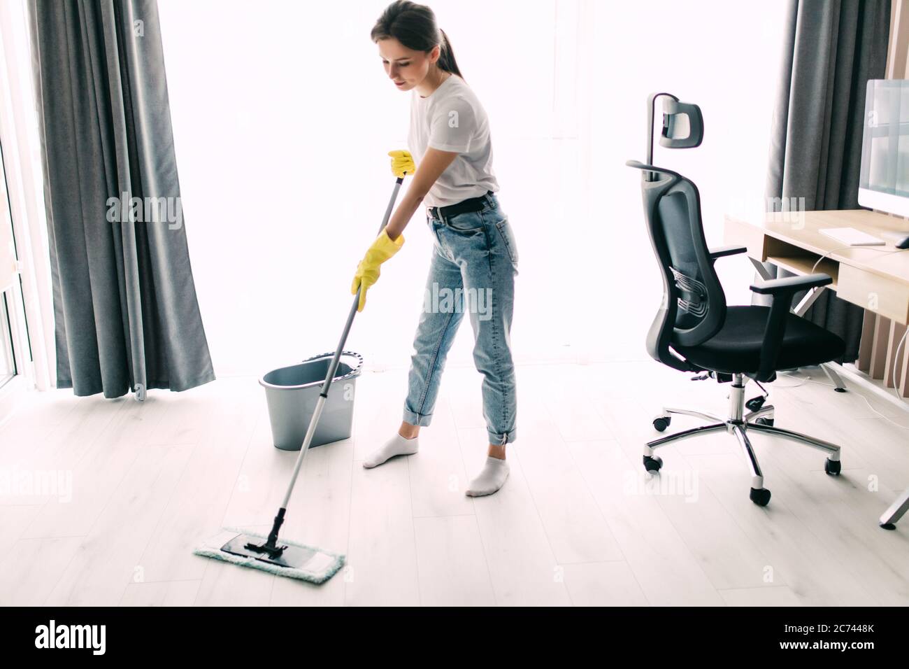 Woman mopping the floor of living room Stock Photo - Alamy