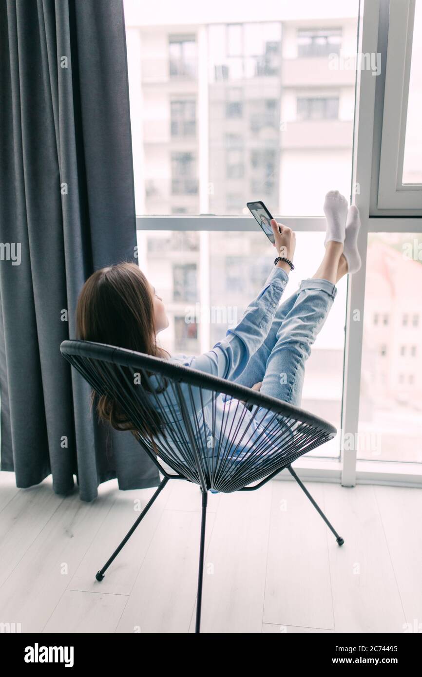 Beautiful smiling woman take selfie at her smart phone while sitting in ...