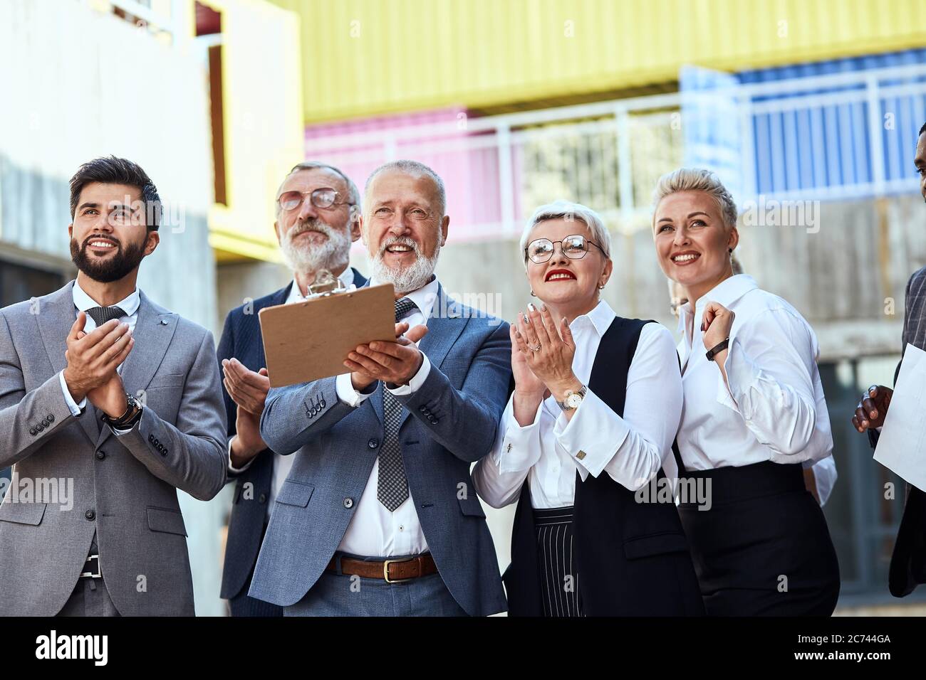 Group of businessmen wear stylish suits in the street give an ...