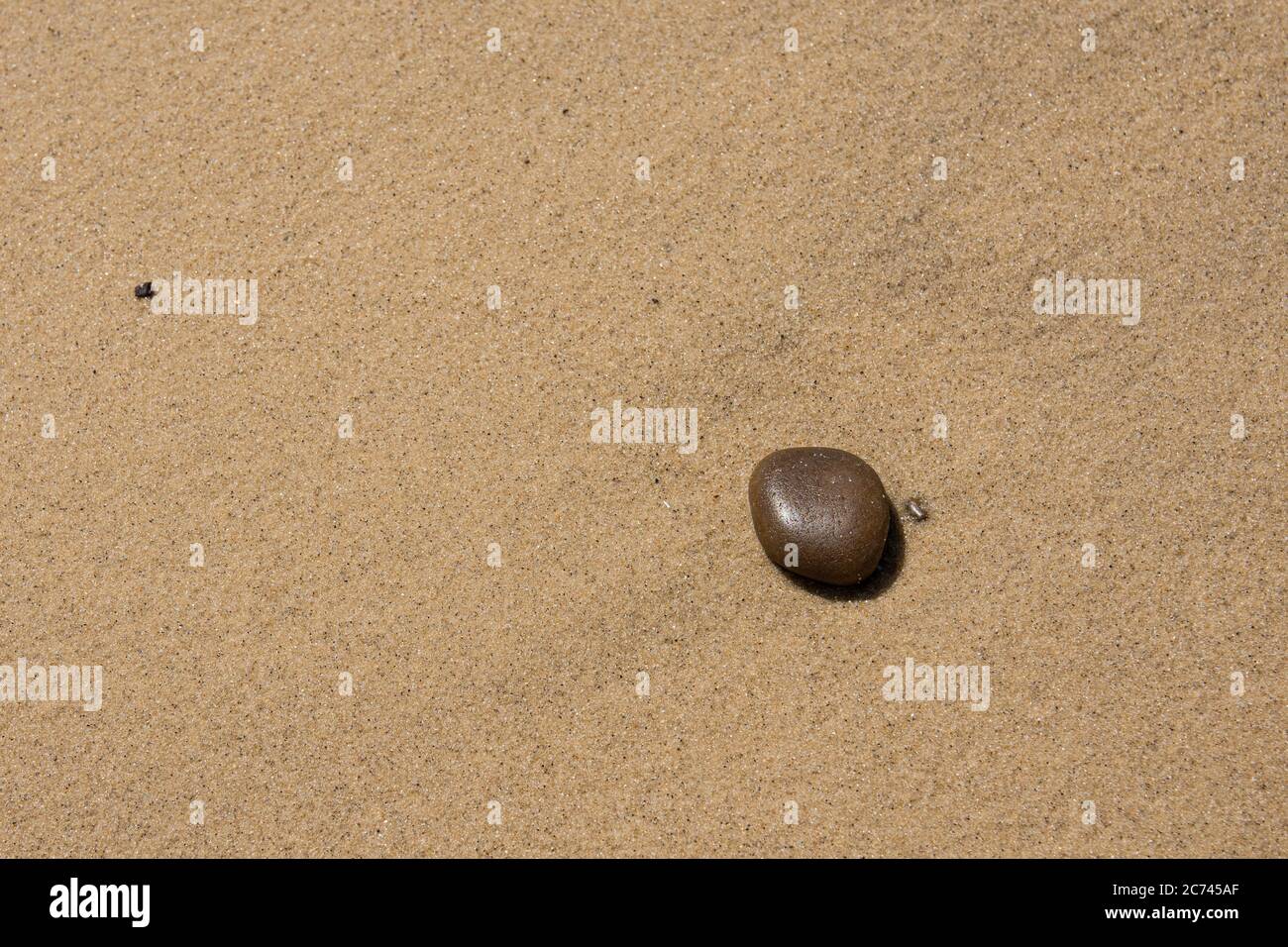 A single smooth beach pebbles against a background of smooth water ...