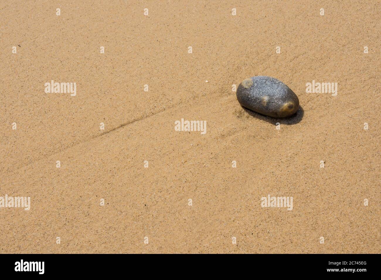 A single smooth beach pebbles against a background of smooth water ...