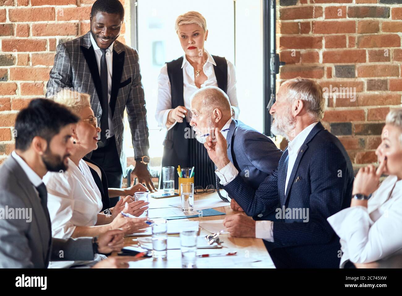 Man suit sitting behind table hi-res stock photography and images - Alamy