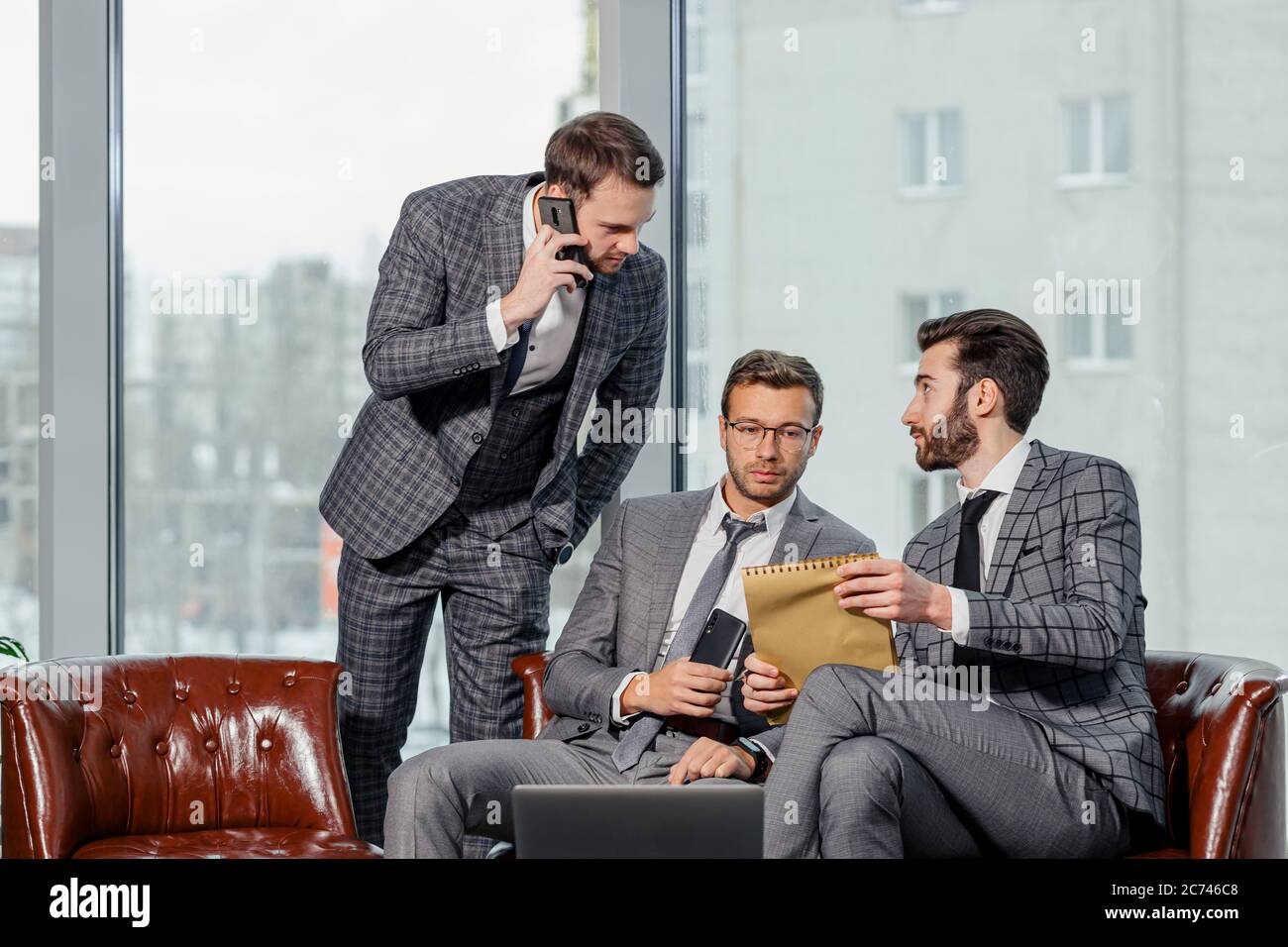 group of young business men gathered together to discuss business ...