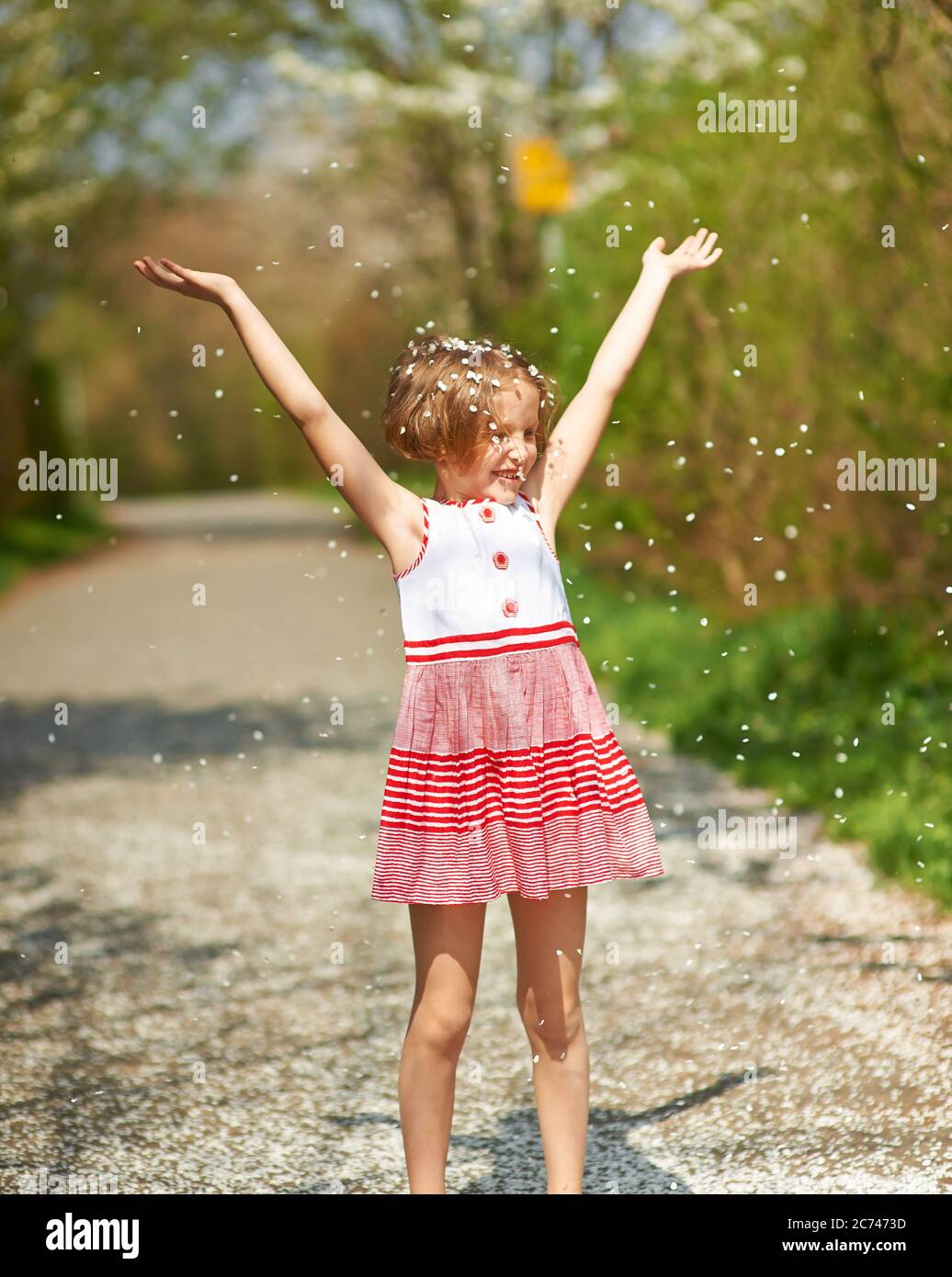 Happy child in spring throws petals in the air Stock Photo - Alamy