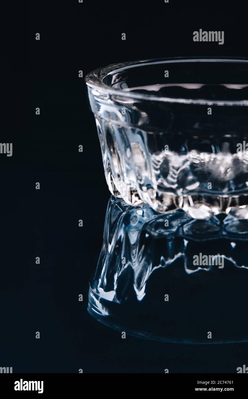 Small low glass bowl on black background Stock Photo - Alamy